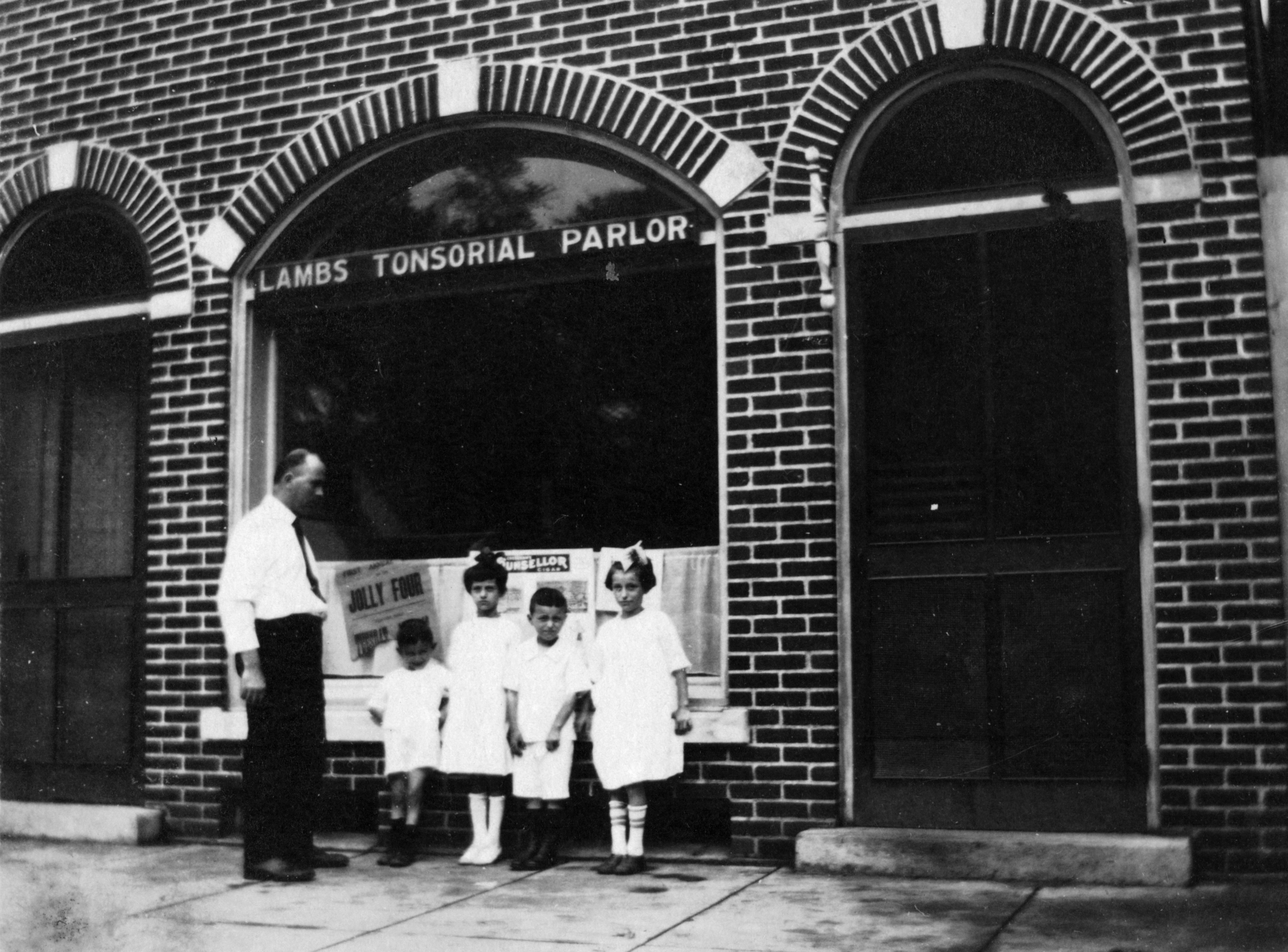 Paul Marasca at his Barber Shop, Lambs Tonsorial Parlor, with Children